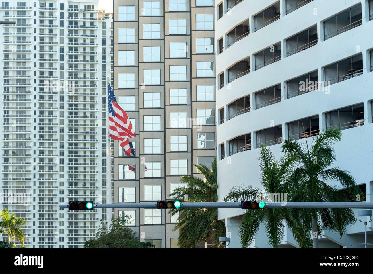 USA national flag waving on wind in front of Miami urban skyline ...