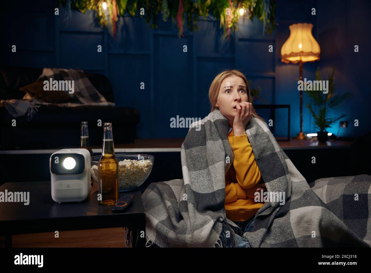 Scared woman watching horror movie on projector Stock Photo - Alamy