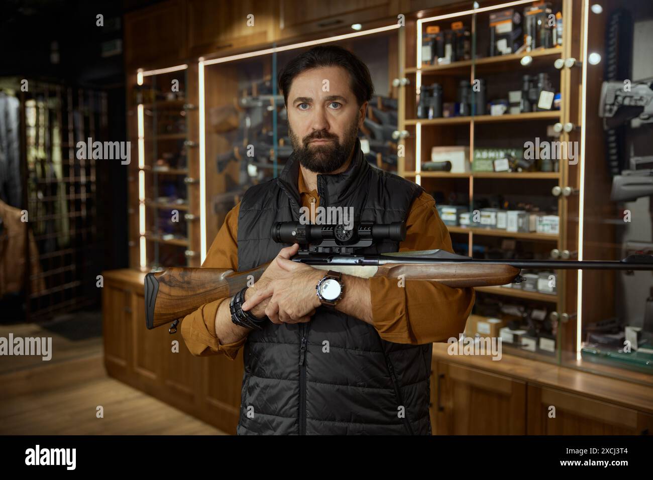 Salesman demonstrating rare collectible hunting rifle over gun shop ...