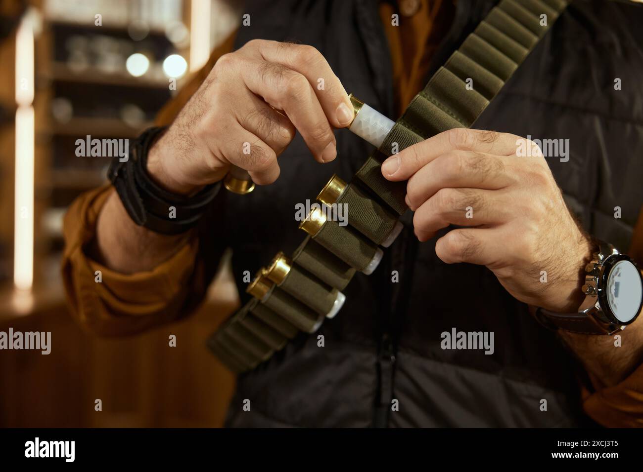 Hunter hands placing bullets into the ammo belt closeup Stock Photo - Alamy