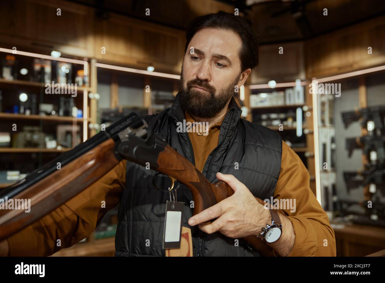 Concentrated salesman checking gun firearm while working at weapon shop ...