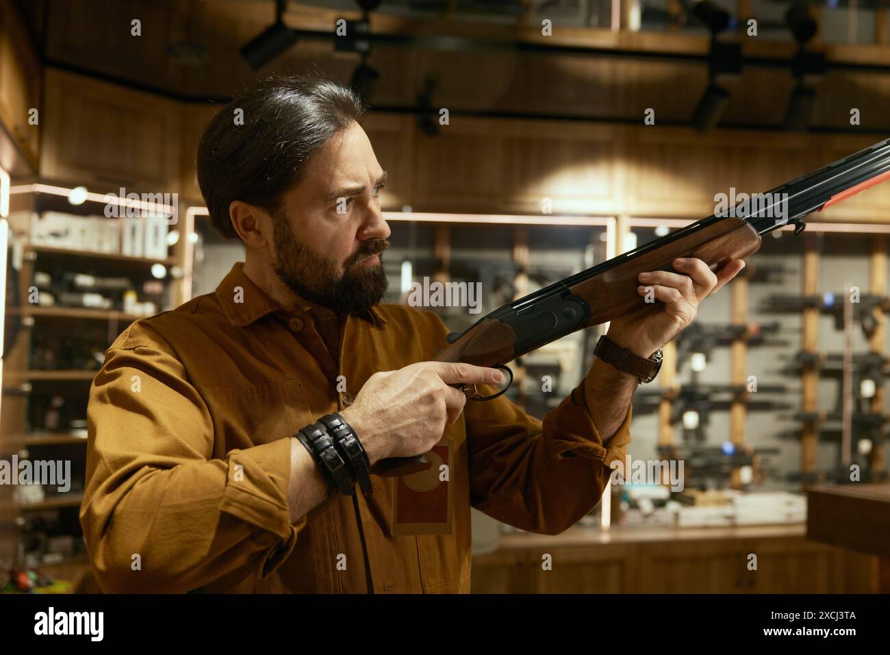 Man choosing rifle checking functionality standing over shop interior ...