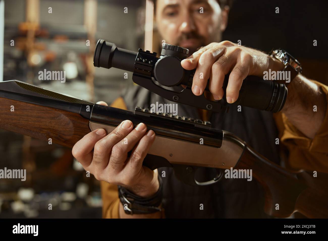 Salesman demonstrating professional accuracy gun assembly at counter ...