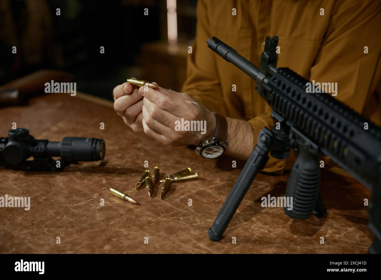 Adult man holding bullets for automatic gun rifle in weapon shop Stock ...