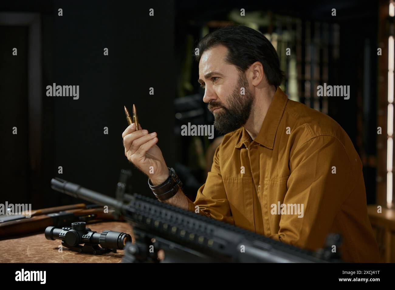 Adult man holding bullets for automatic gun rifle in weapon shop Stock ...