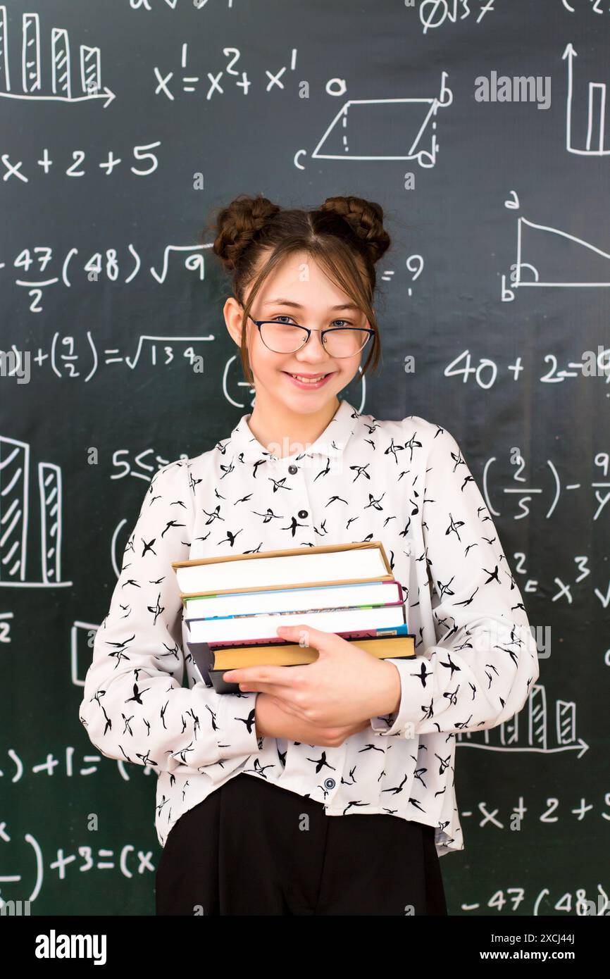 Schoolgirl girl in vision glasses in a white blouse with books her ...