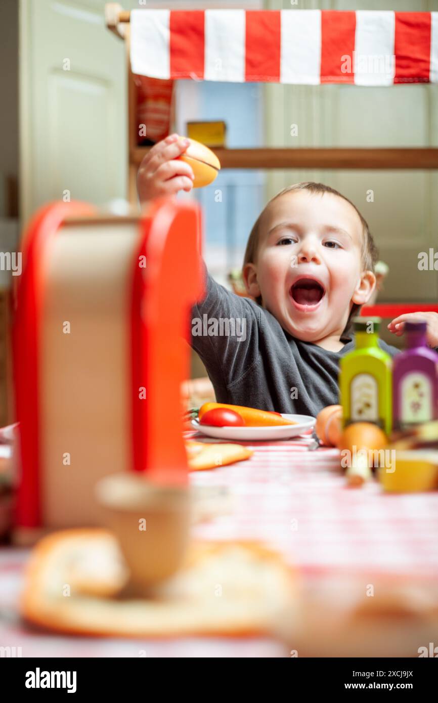 Excited child during his cooking game in playroom, Symbolic play Stock ...