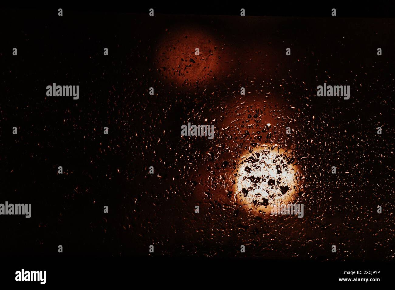 Raindrops and condensation on window at night with street lights ...