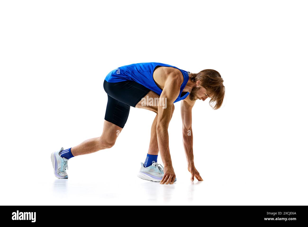 Ready, steady, go. Muscular man, runner standing on starting line ...