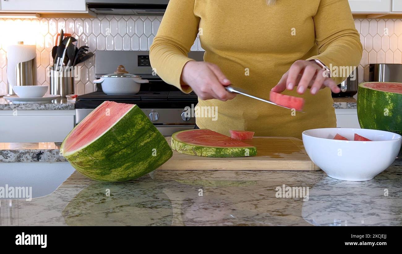 Woman Slicing Watermelon in a Modern Kitchen Stock Photo - Alamy