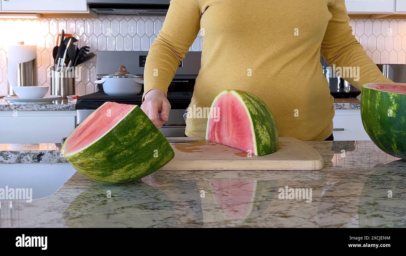 Woman Slicing Watermelon in a Modern Kitchen Stock Photo - Alamy