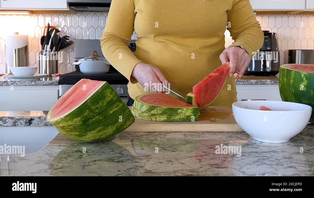 Woman Slicing Watermelon in a Modern Kitchen Stock Photo - Alamy
