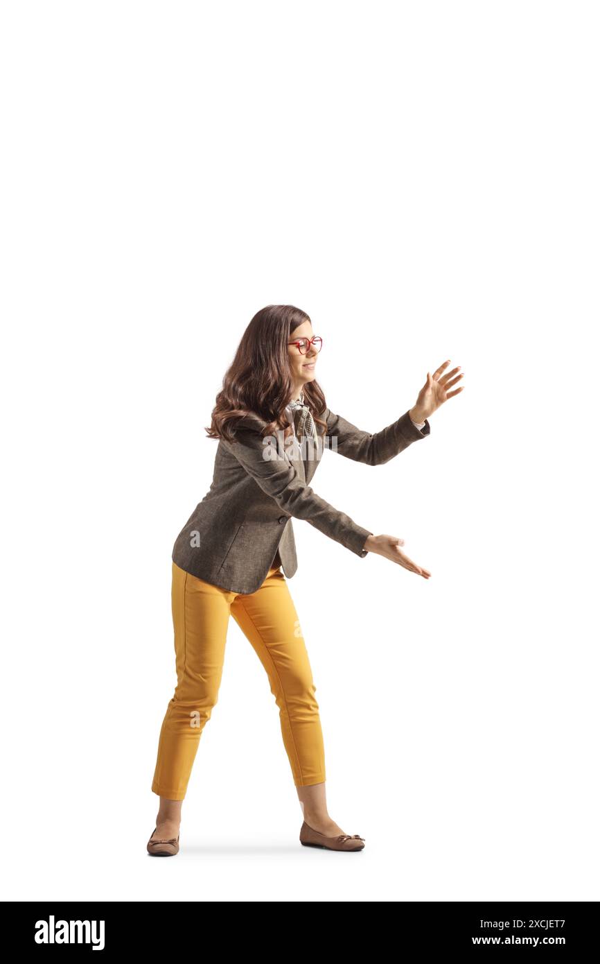 Full length profile shot of a young woman catching something isolated ...