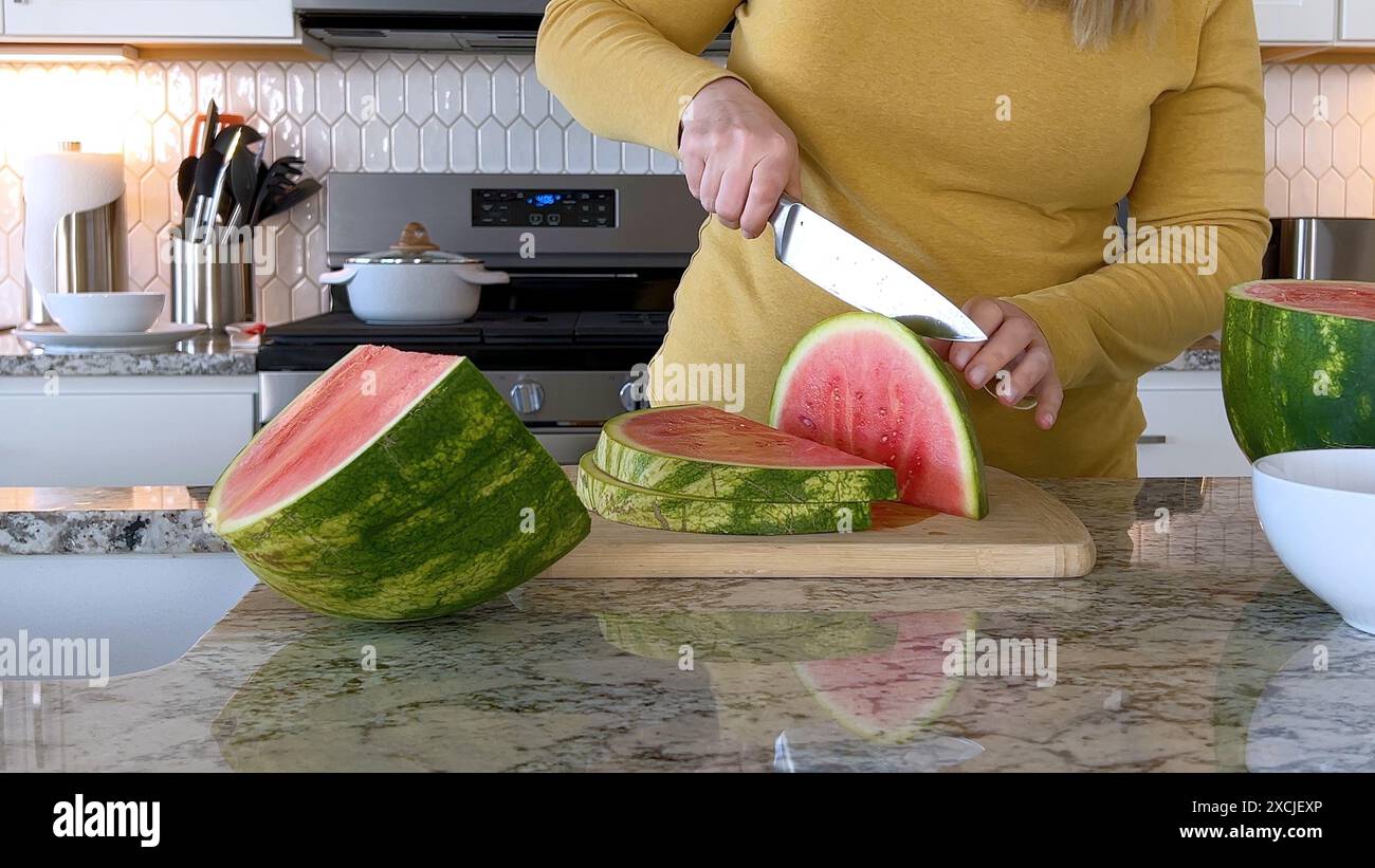 Woman Slicing Watermelon in a Modern Kitchen Stock Photo - Alamy