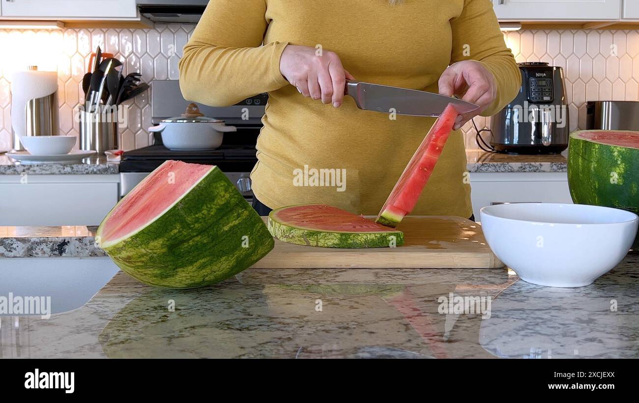 Woman Slicing Watermelon in a Modern Kitchen Stock Photo - Alamy