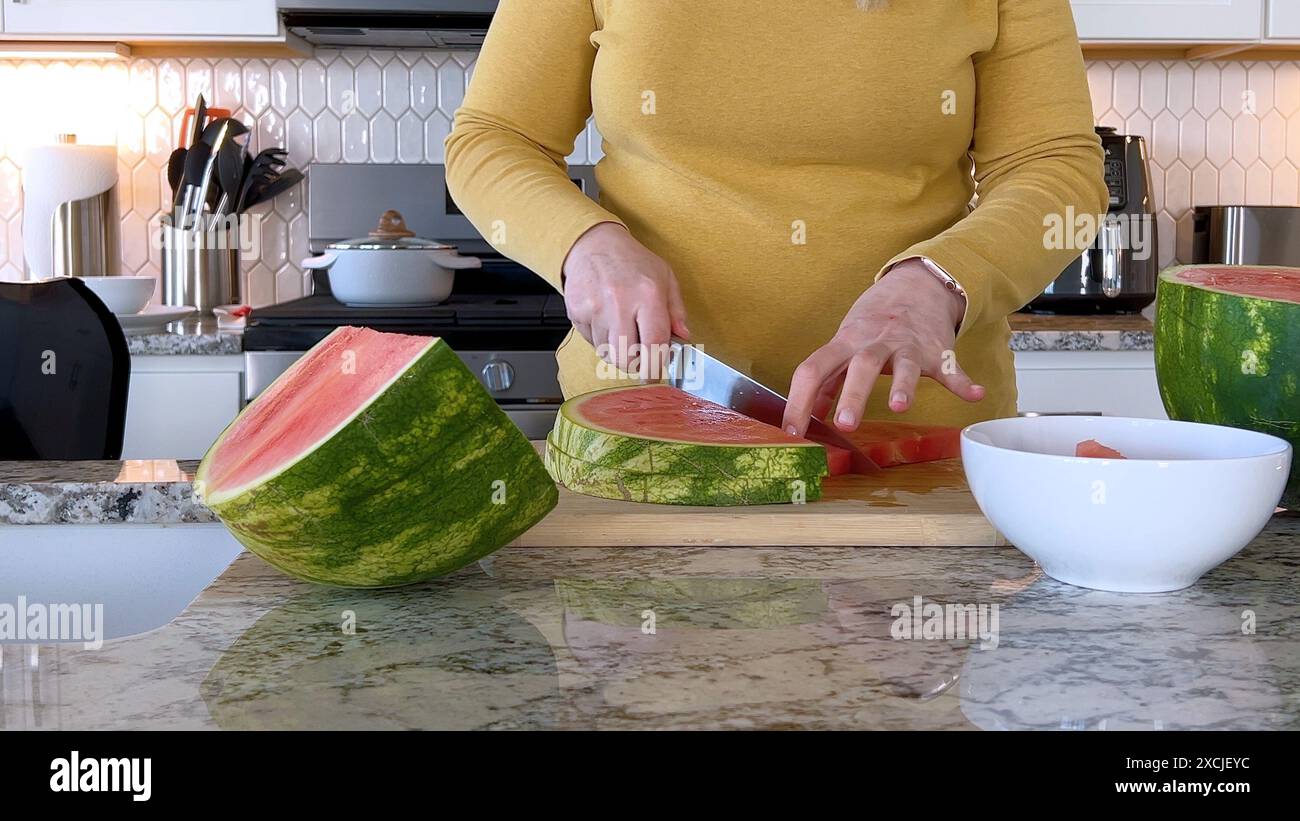 Woman Slicing Watermelon in a Modern Kitchen Stock Photo - Alamy