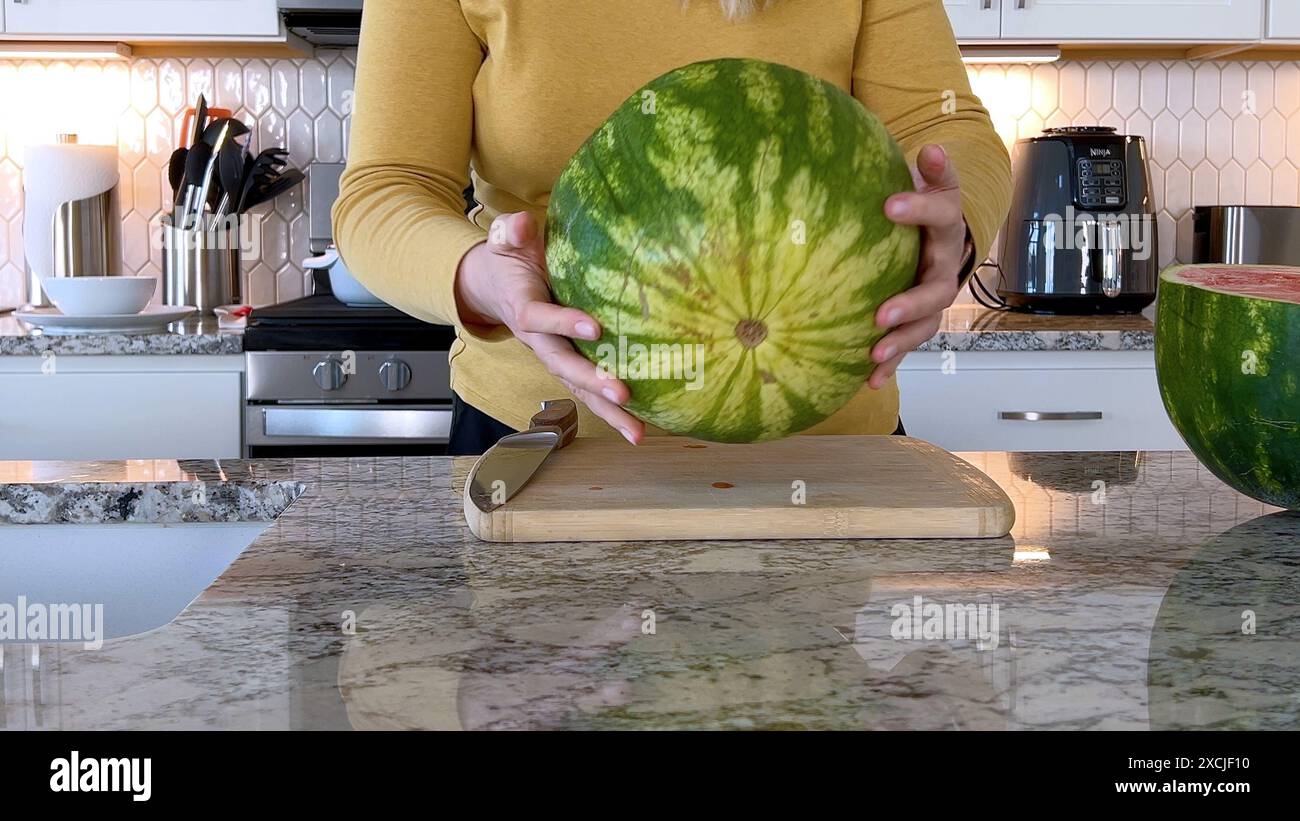 Woman Slicing Watermelon in a Modern Kitchen Stock Photo - Alamy