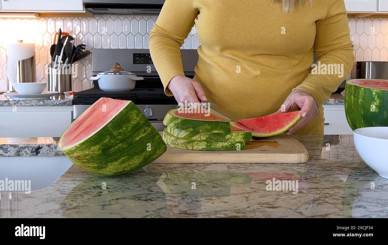 Woman Slicing Watermelon in a Modern Kitchen Stock Photo - Alamy