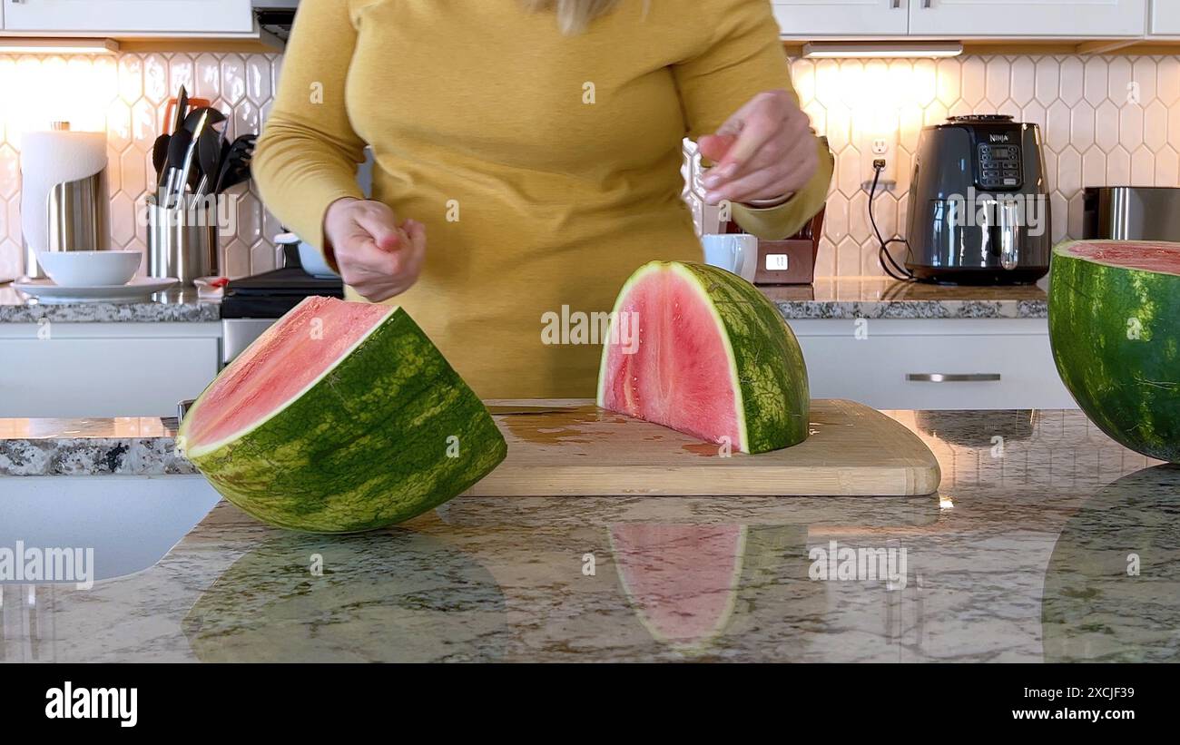 Woman Slicing Watermelon in a Modern Kitchen Stock Photo - Alamy