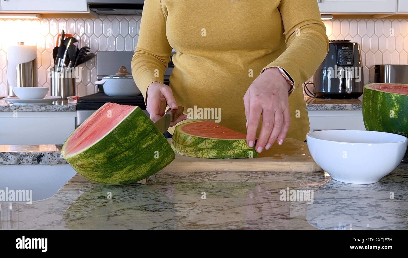 Woman Slicing Watermelon in a Modern Kitchen Stock Photo - Alamy