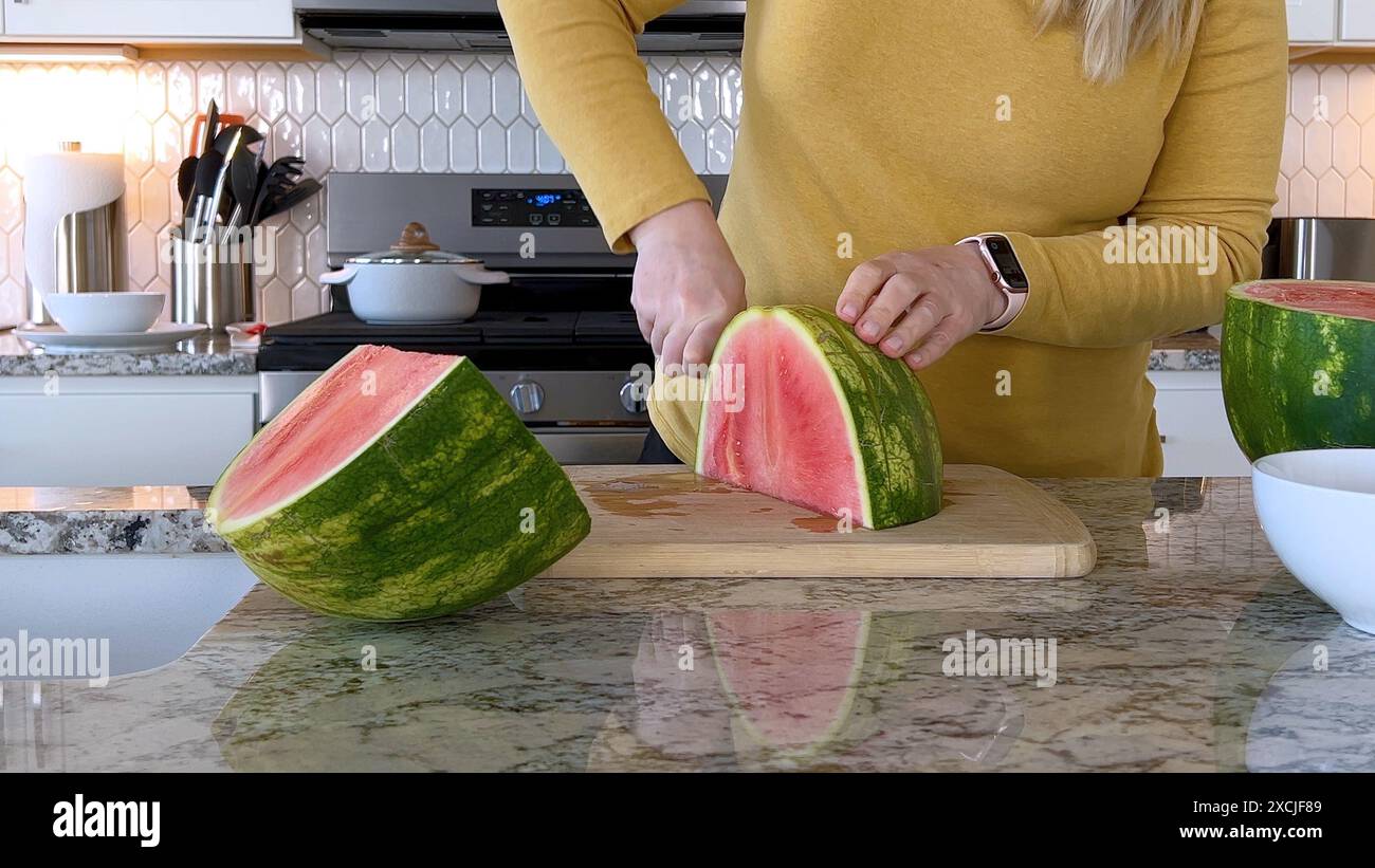 Woman Slicing Watermelon in a Modern Kitchen Stock Photo - Alamy