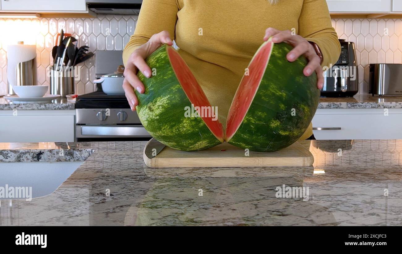 Woman Slicing Watermelon in a Modern Kitchen Stock Photo - Alamy