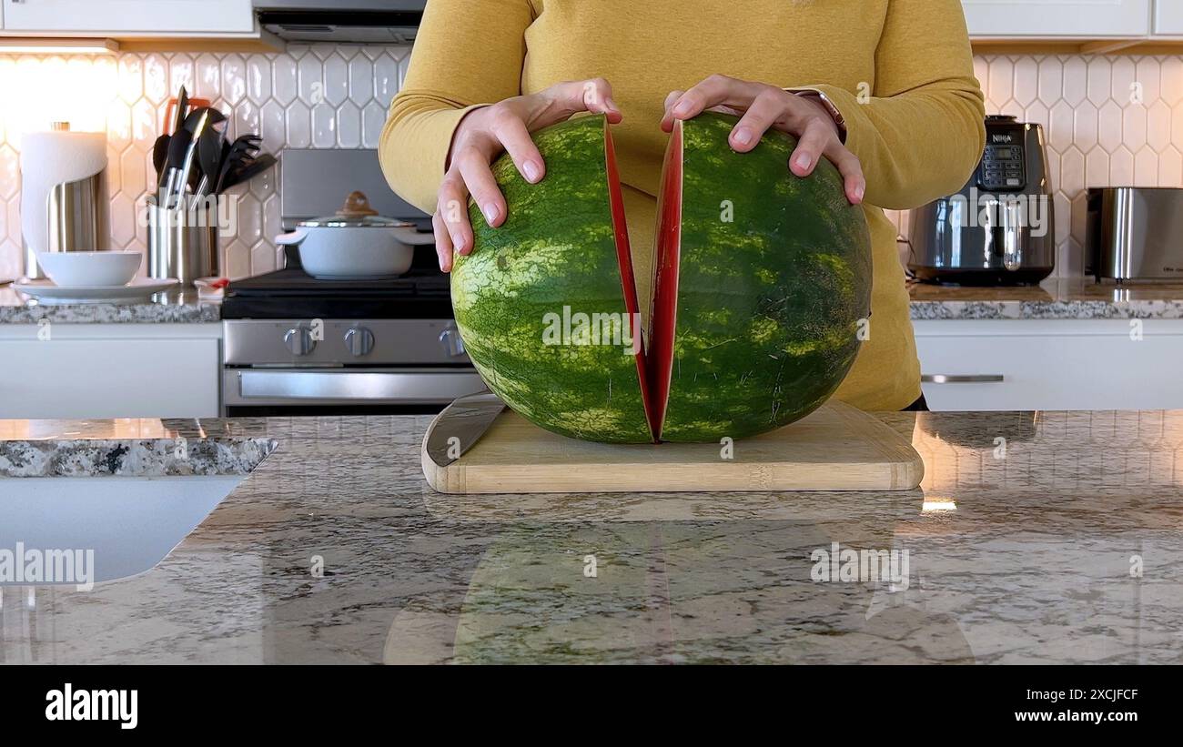 Woman Slicing Watermelon in a Modern Kitchen Stock Photo - Alamy