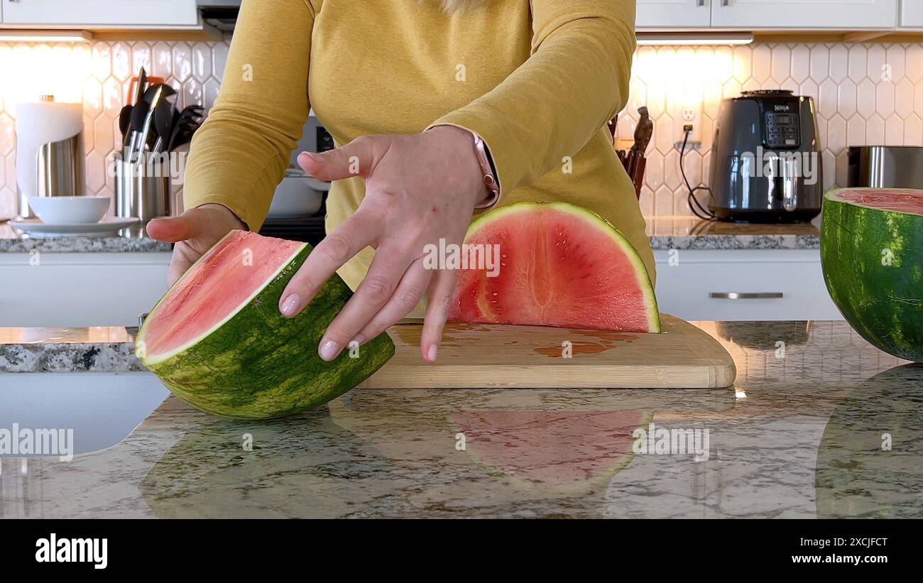 Woman Slicing Watermelon in a Modern Kitchen Stock Photo - Alamy