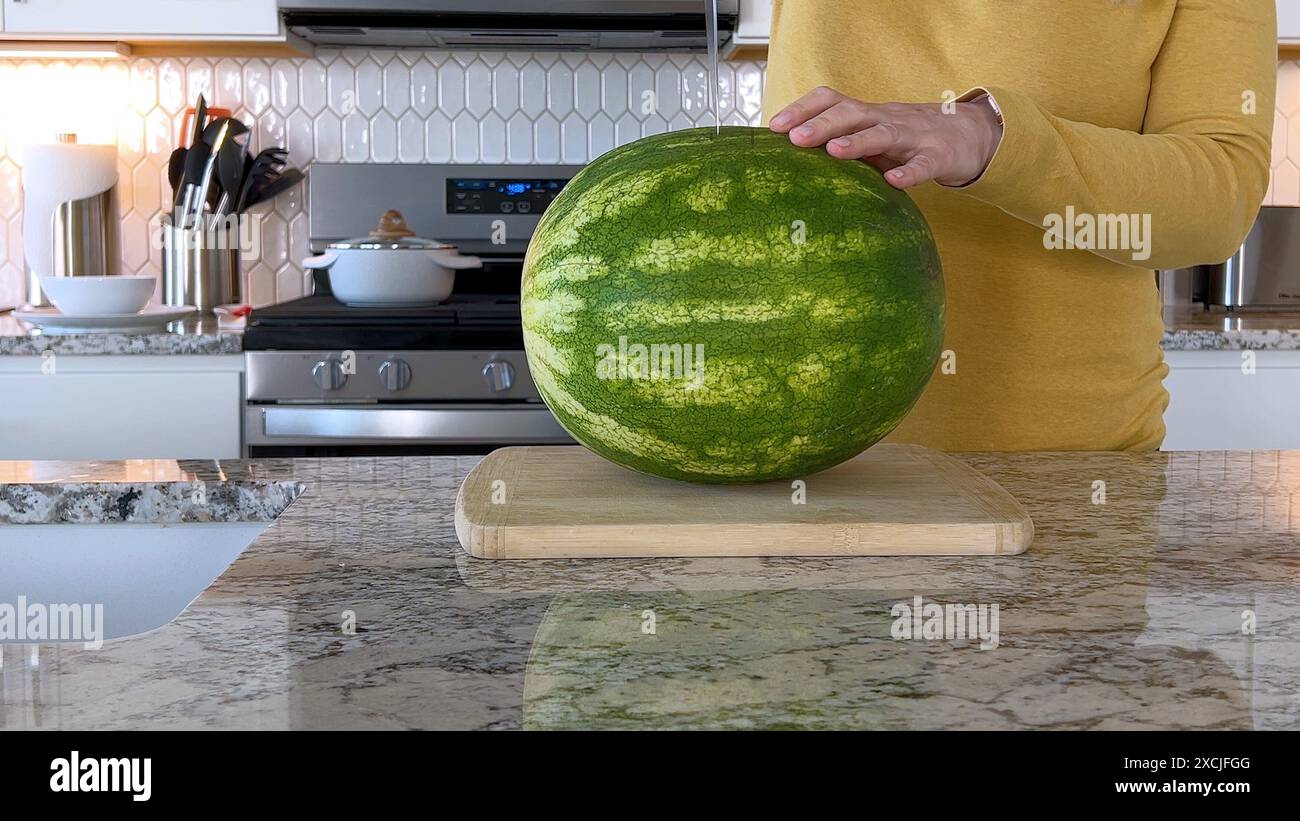 Woman Slicing Watermelon in a Modern Kitchen Stock Photo - Alamy