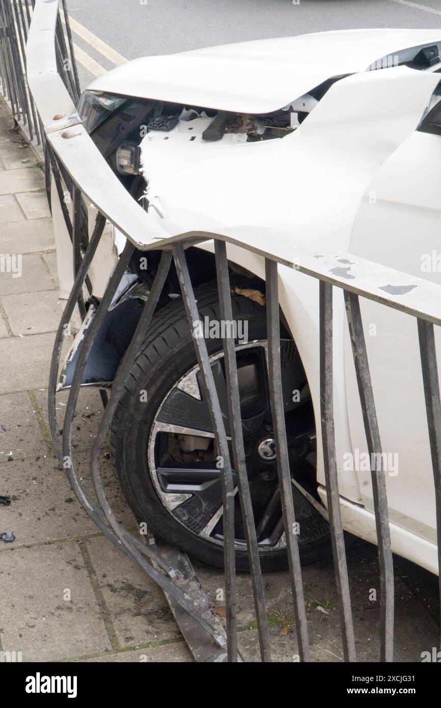 The front left wing of a white car that has crashed into railings ...