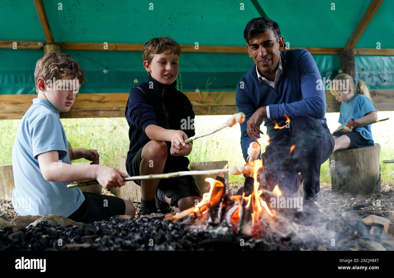 Prime Minister Rishi Sunak toasts bread on an open fire with children ...