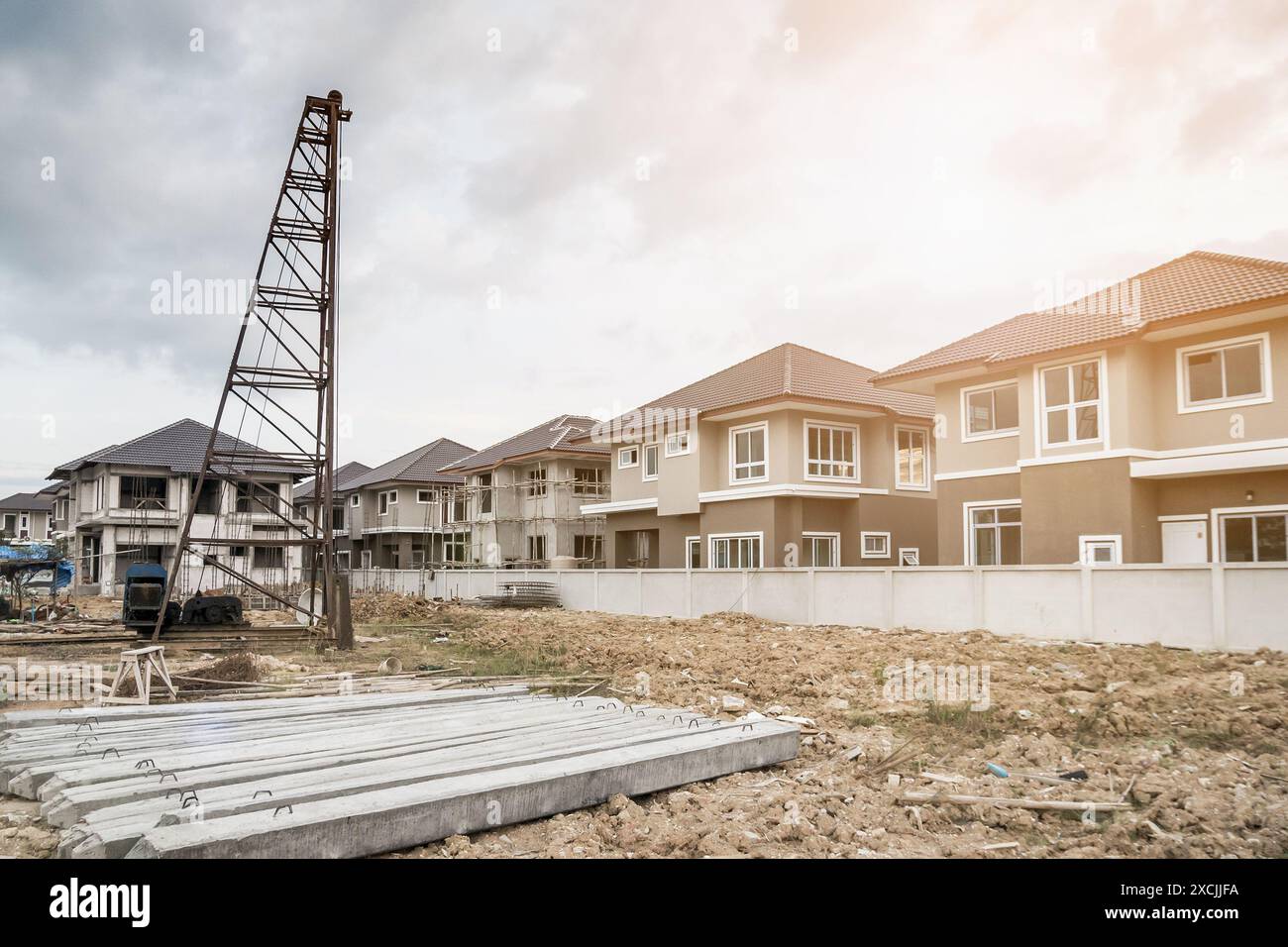 house building at construction site with pile driver and precast ...