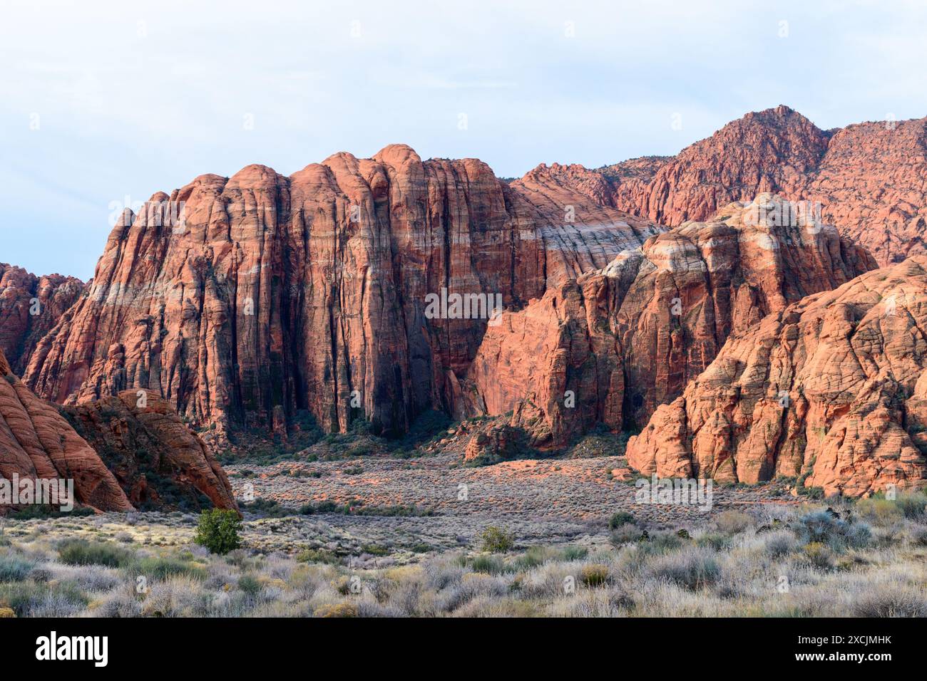 The towering red Navajo sandstone cliffs at Snow Canyon State Park. The ...