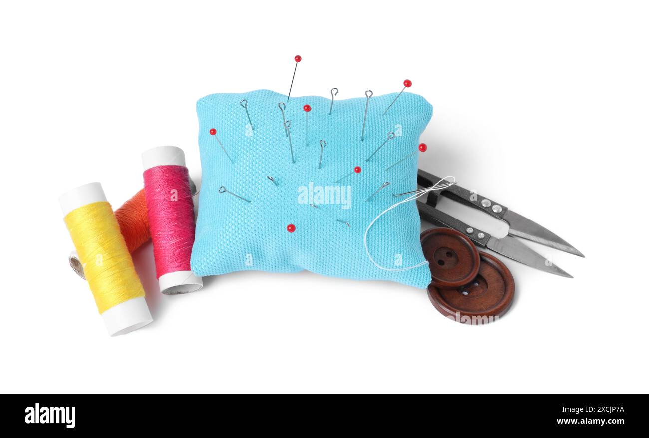 Light blue pincushion with sewing pins, spools of threads, cutter and ...