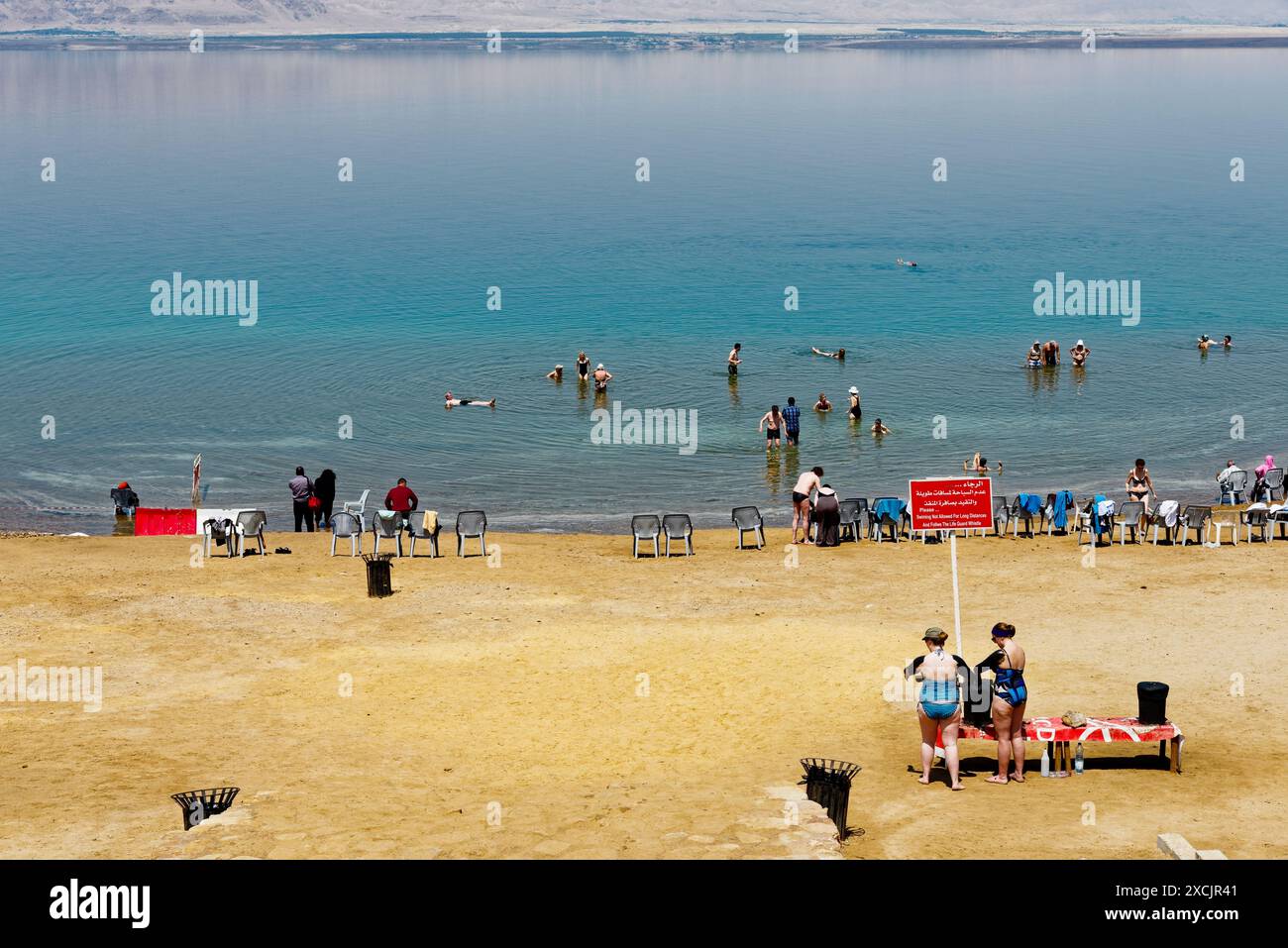 People relaxing on sandy beach of Dead Sea, Jordan Stock Photo - Alamy