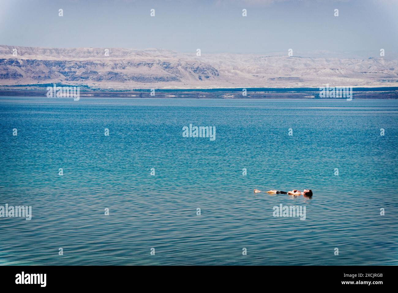 Person leisurely floating on surface of Dead Sea, Jordan Stock Photo ...
