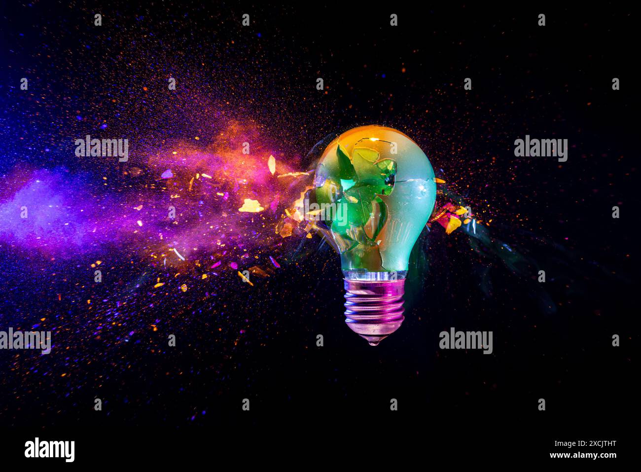 Broken light bulb exploding with colorful powder on a black background ...