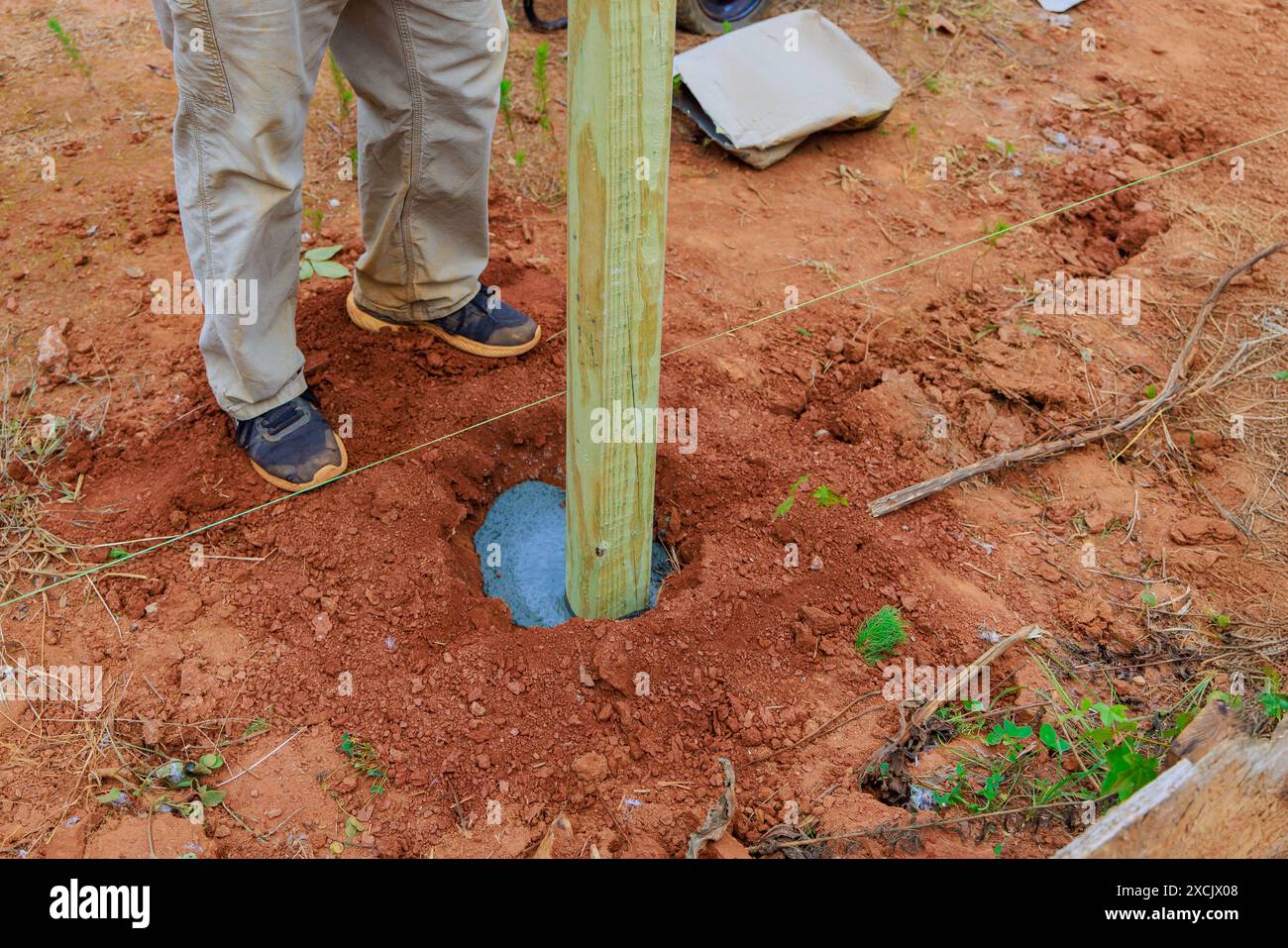 Concrete pouring on newly installed timber fencing wood fence posts ...