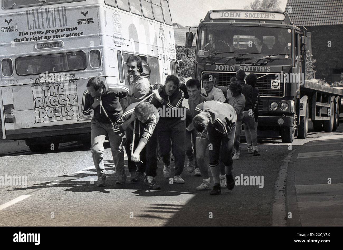 1980s, historical, outside on the road, a group of men doing a charity ...