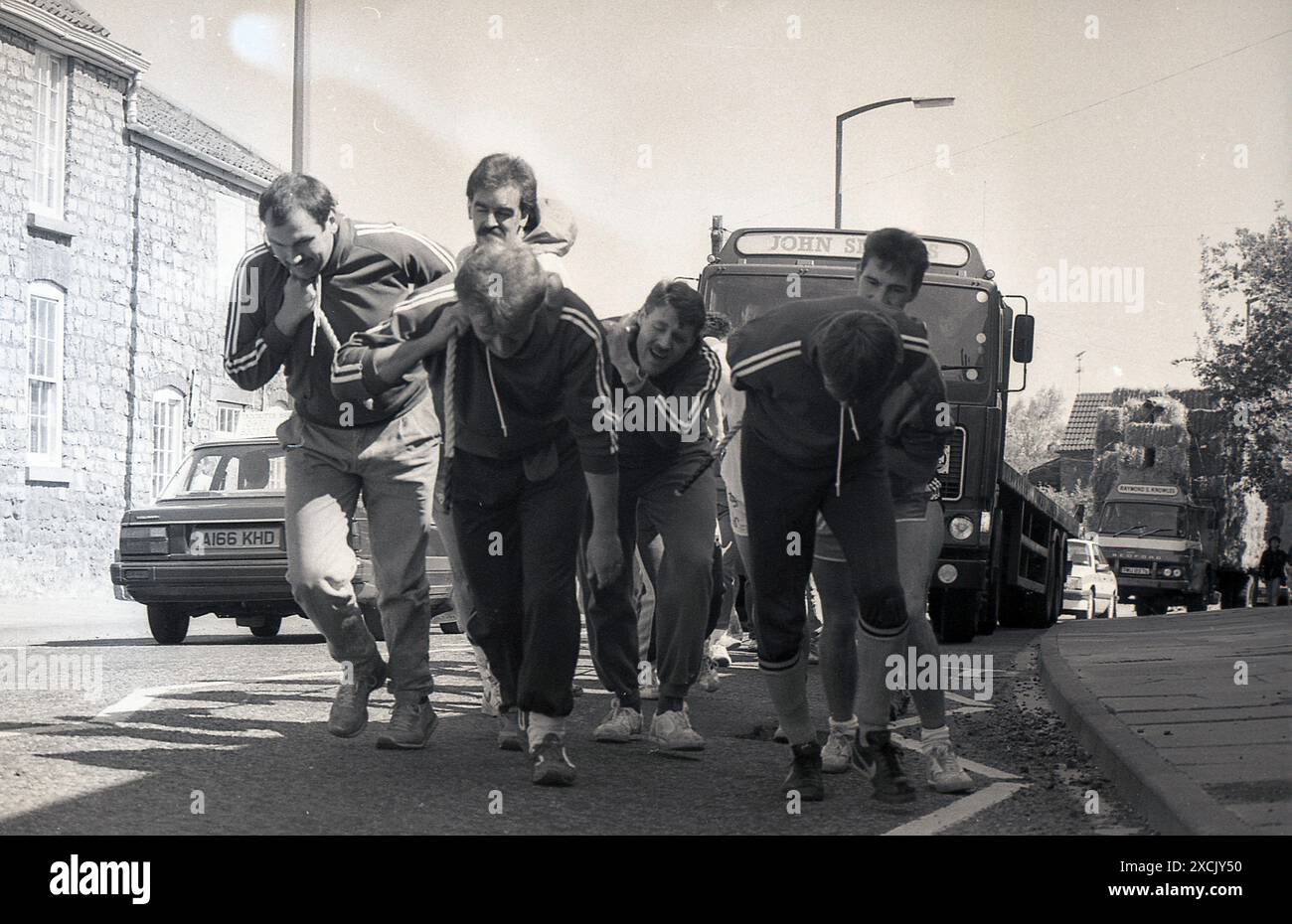 1980s, historical, outside on the road, a group of men doing a charity ...