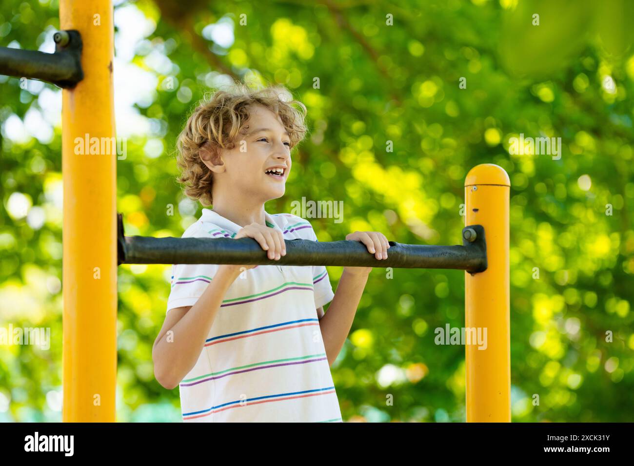 Child on playground. Active kid exercising in school yard. Children play and climb. Little boy ...