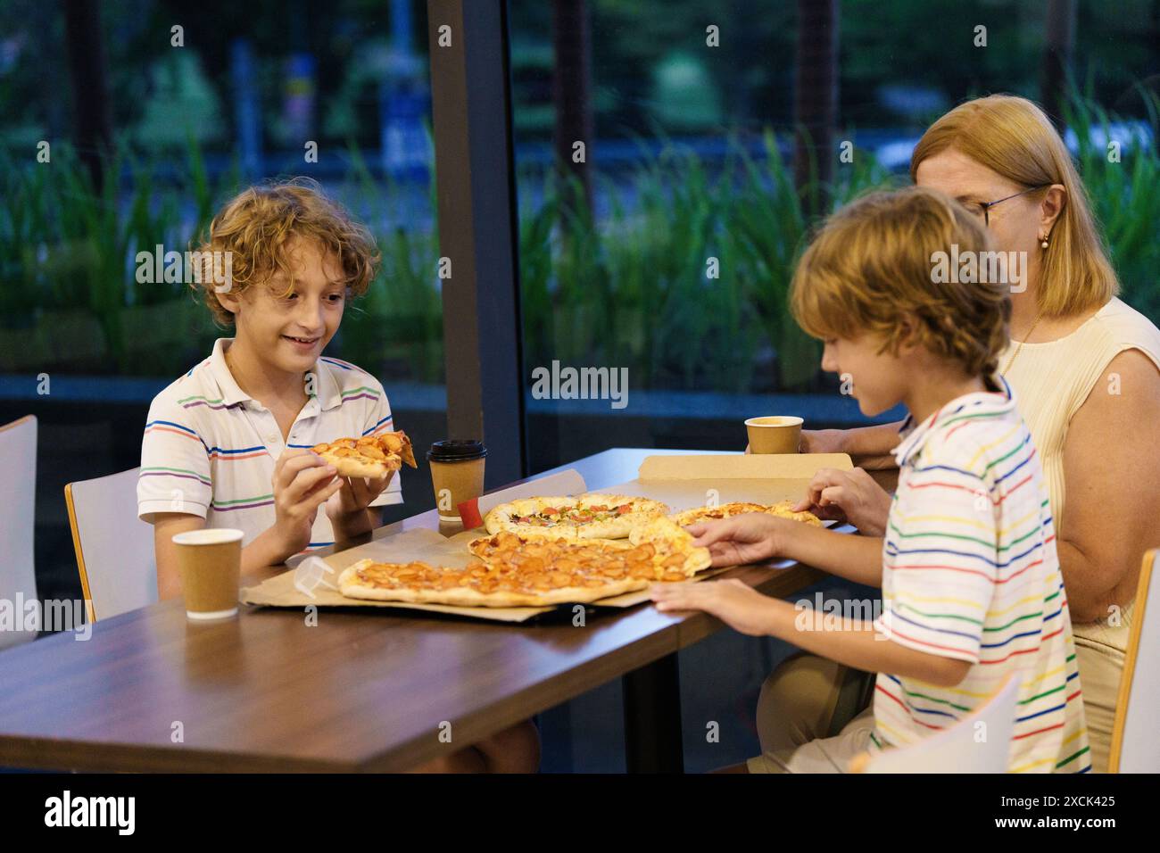 Family eating pizza in Italian restaurant. Mother and kids order fresh ...