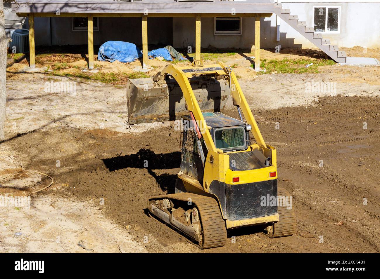 An earthmoving tractor is leveling ground at construction site for ...