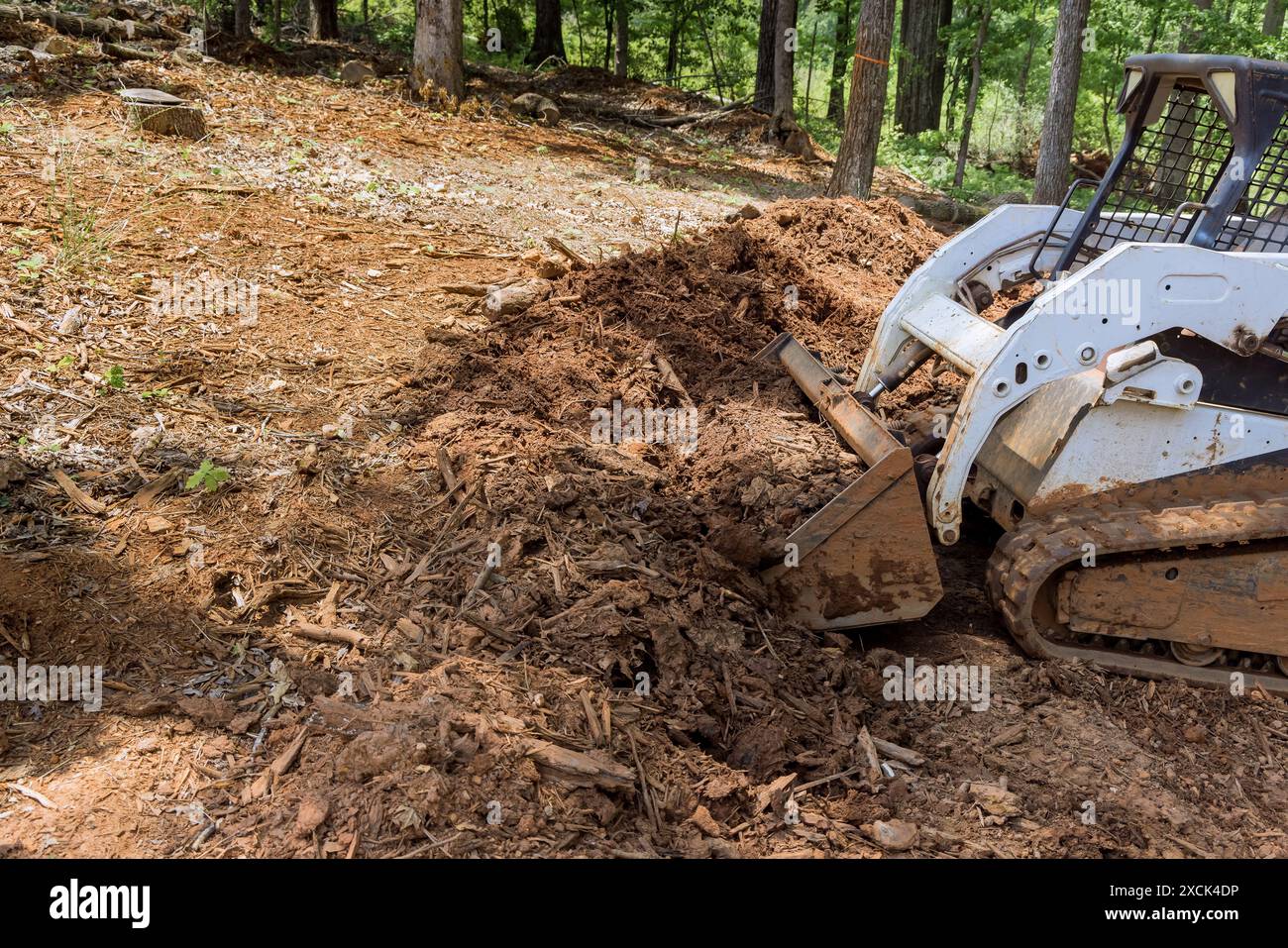 Tractor leveling ground at an earthmoving site in preparation for ...