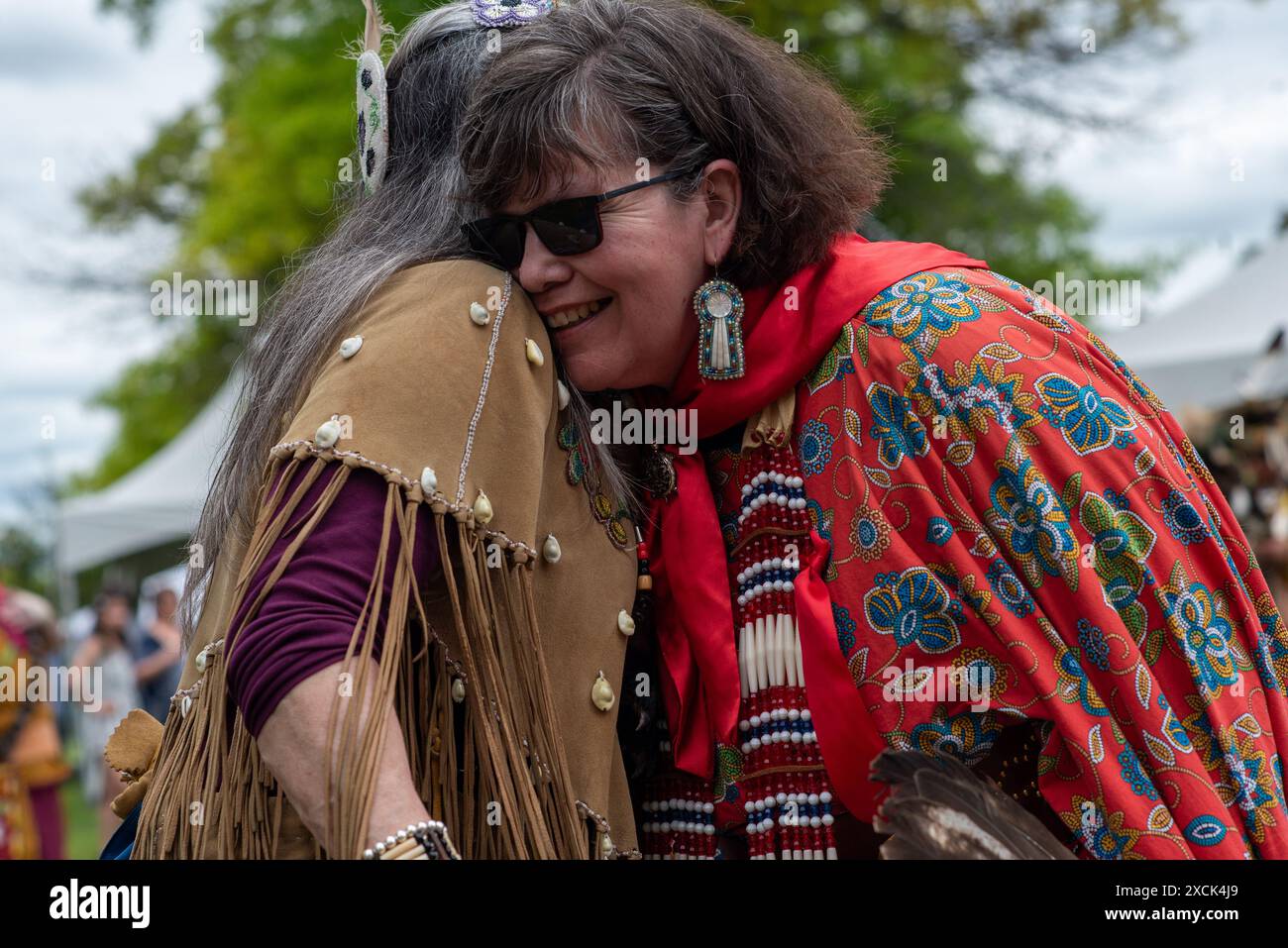 Senior Indigenous first nation women hugging happy wearing typical ...
