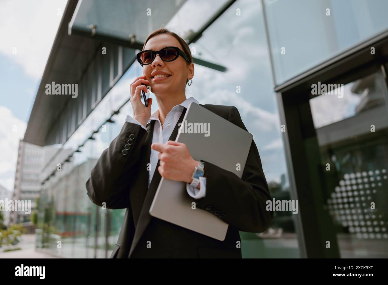 Confident businesswoman having a phone conversation in front of a ...