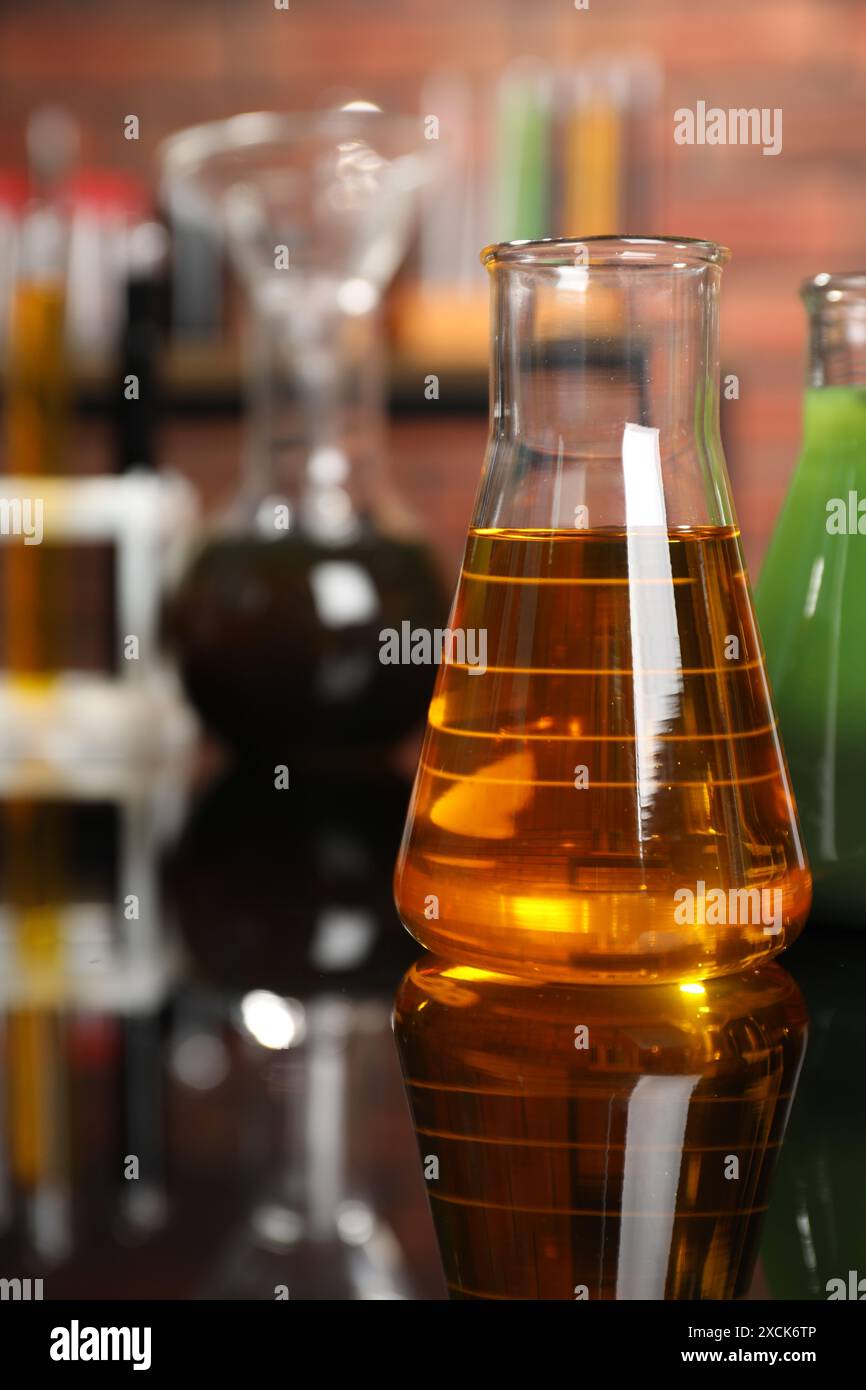 Laboratory glassware with different types of oil on mirror table ...