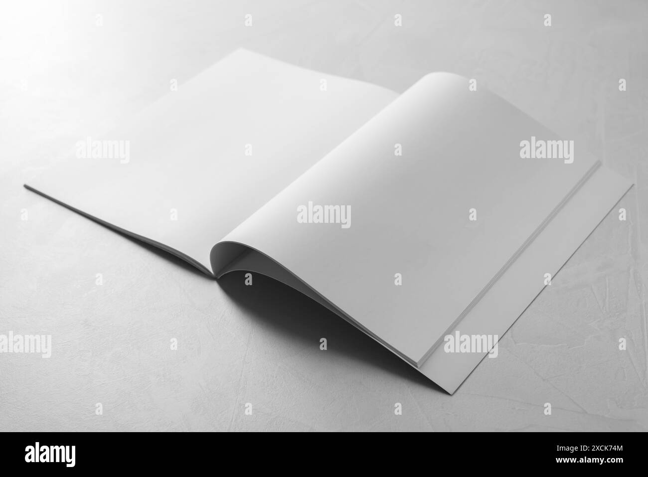 Open notebook with blank paper sheets on grey textured table. Mockup ...
