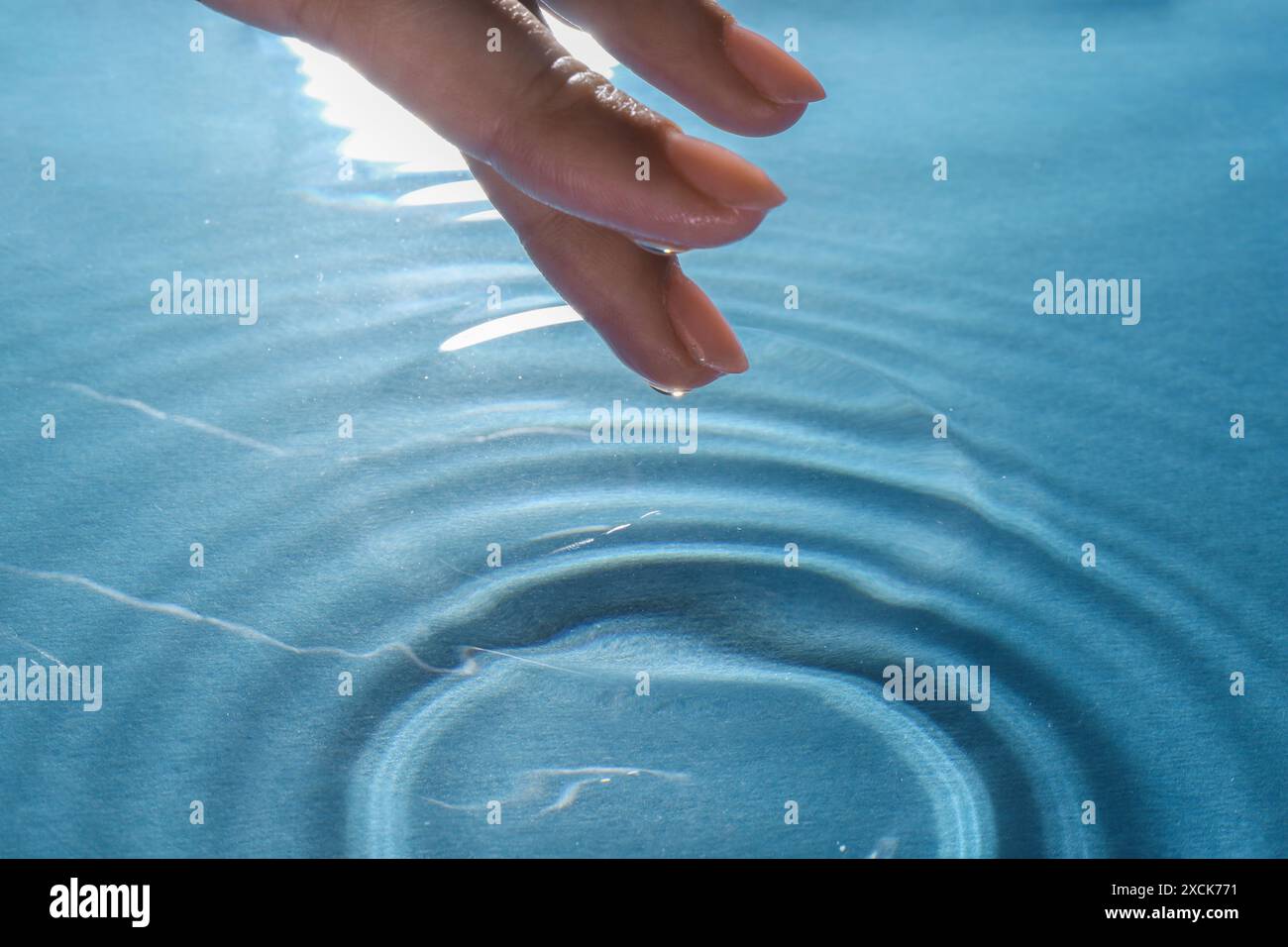 Woman touching clear water, closeup. Making ripples Stock Photo - Alamy