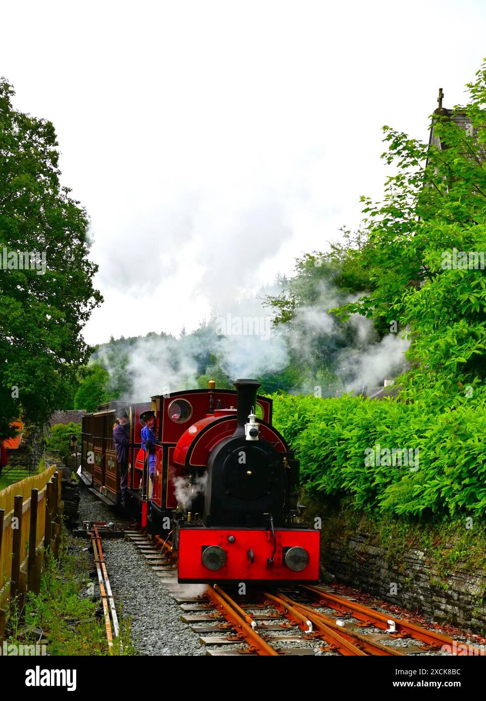 Two red Falcon steam engines pulling carriages on the approach to ...
